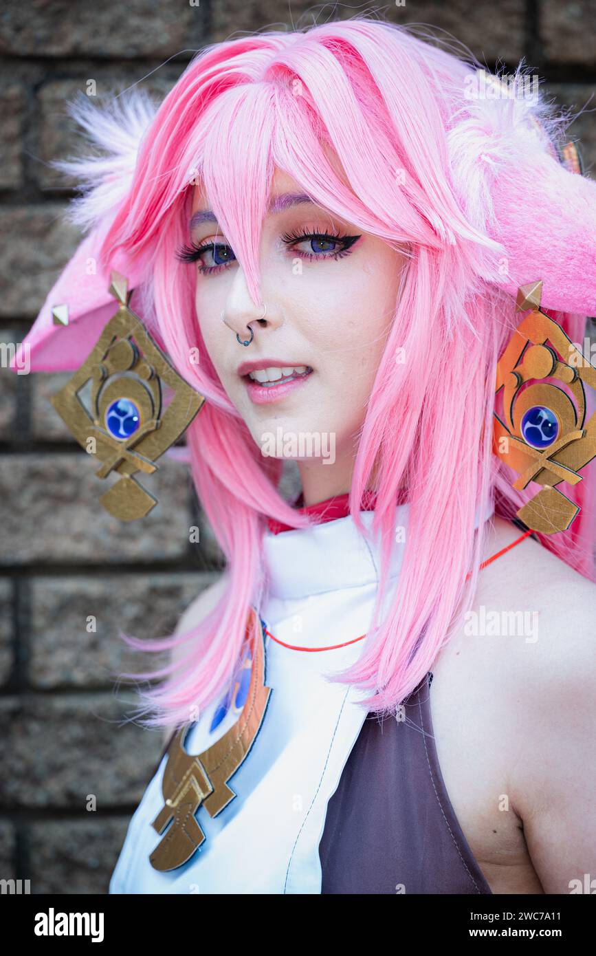 A Female cosplayer in a pink anime costume wearing pink hair Stock ...