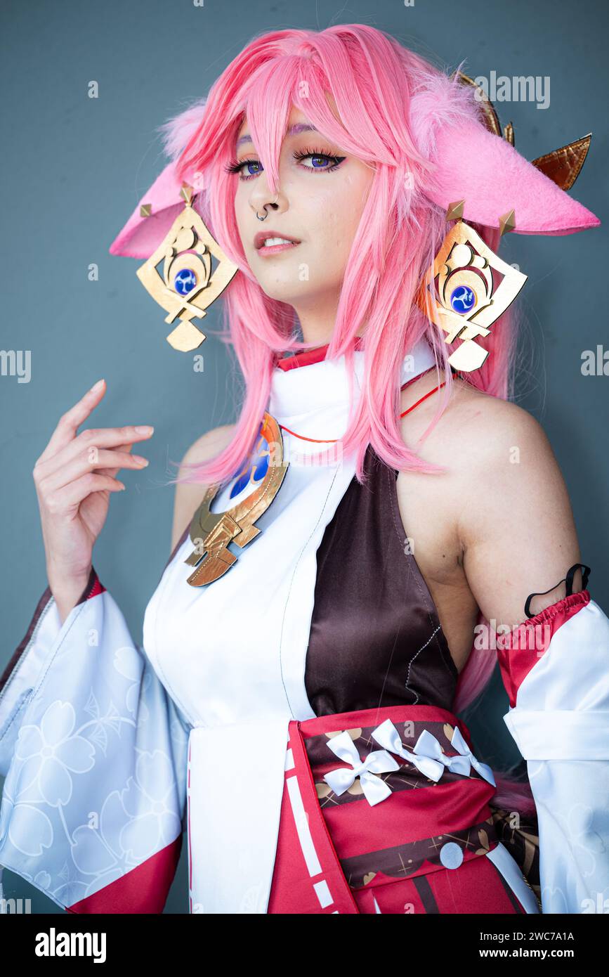 A Female cosplayer in a pink anime costume wearing pink hair Stock ...