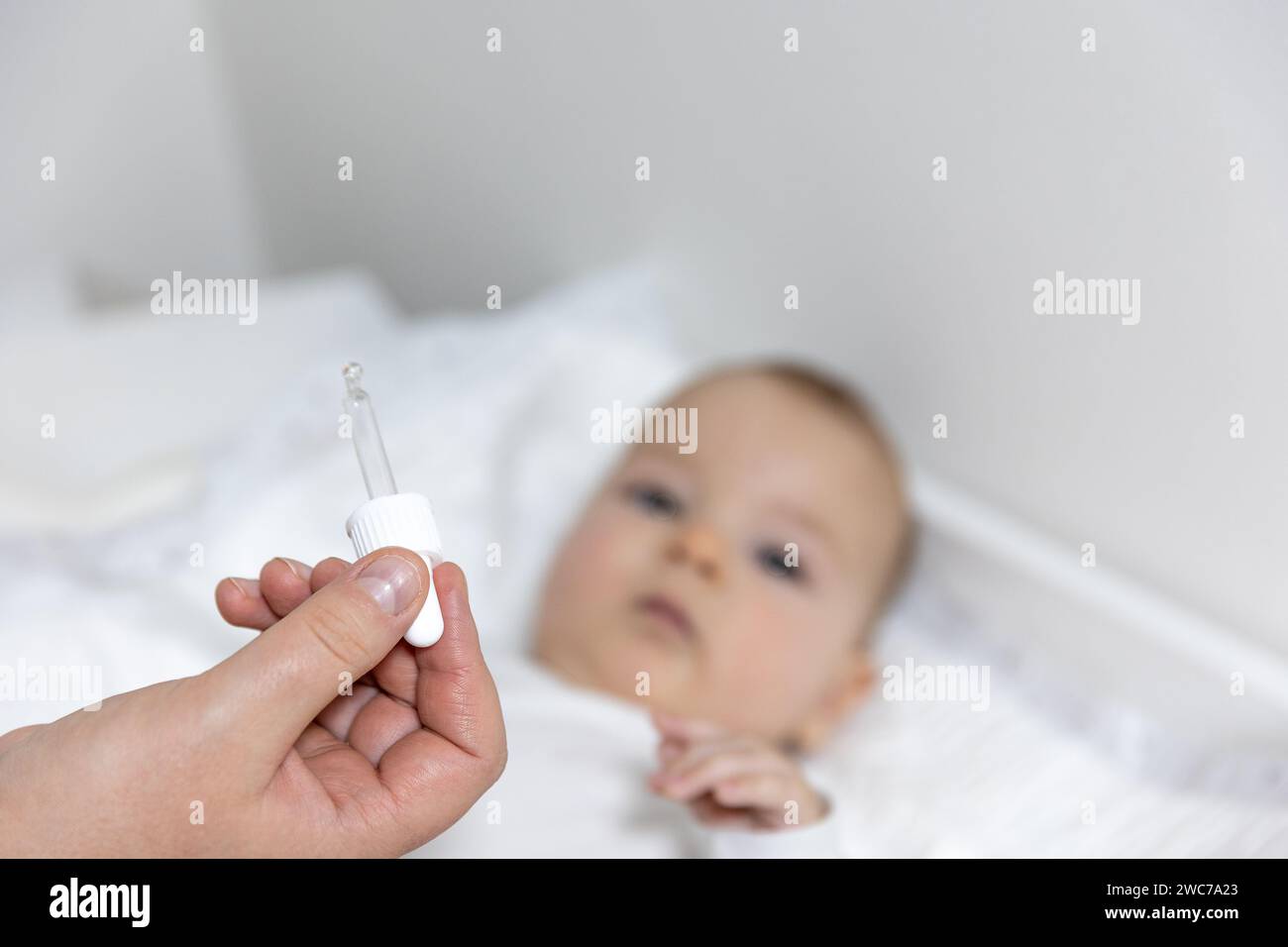 Mom giving vitamin D3 to newborn baby for care of the proper ...