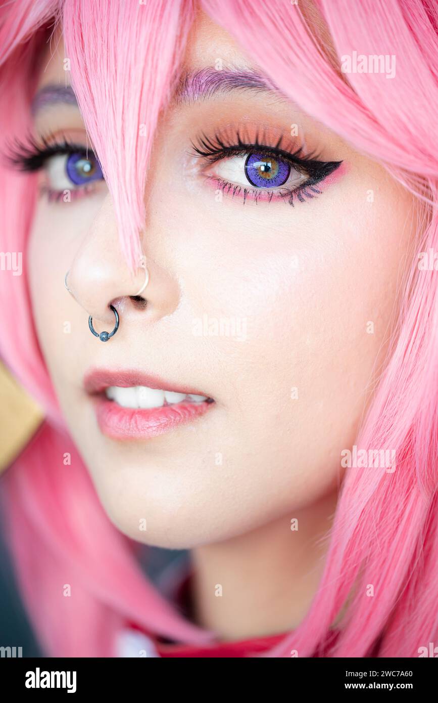 A Female cosplayer in a pink anime costume wearing pink hair Stock ...
