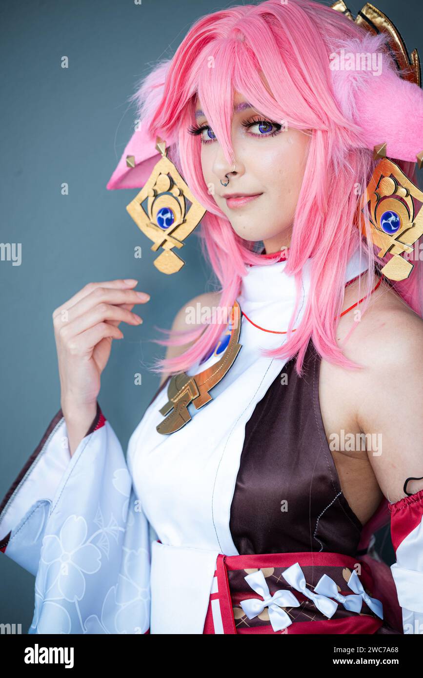 A Female cosplayer in a pink anime costume wearing pink hair Stock ...