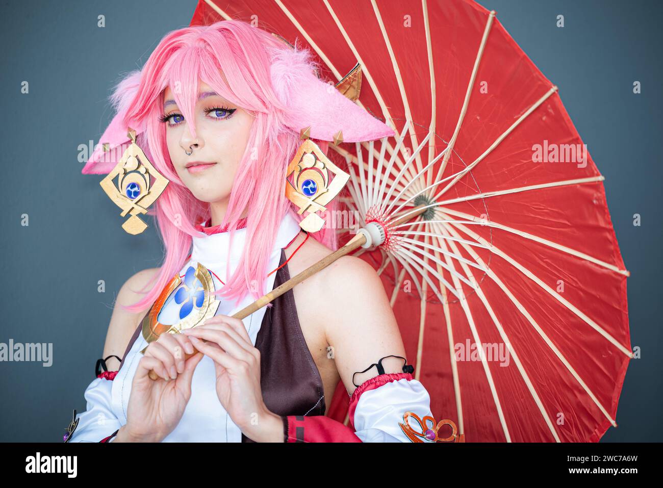 A Female cosplayer in a pink anime costume wearing pink hair Stock ...