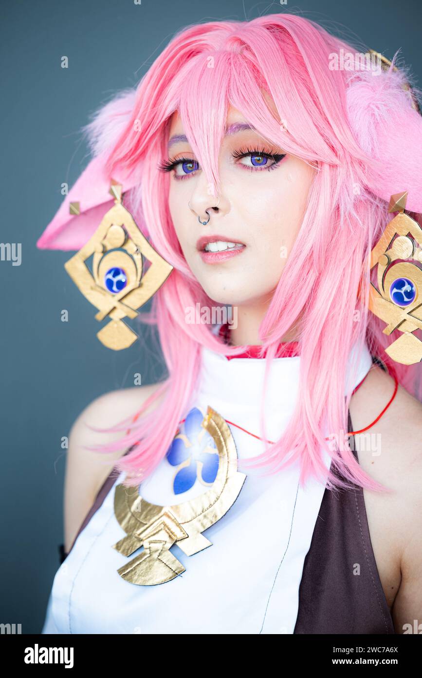 A Female cosplayer in a pink anime costume wearing pink hair Stock ...