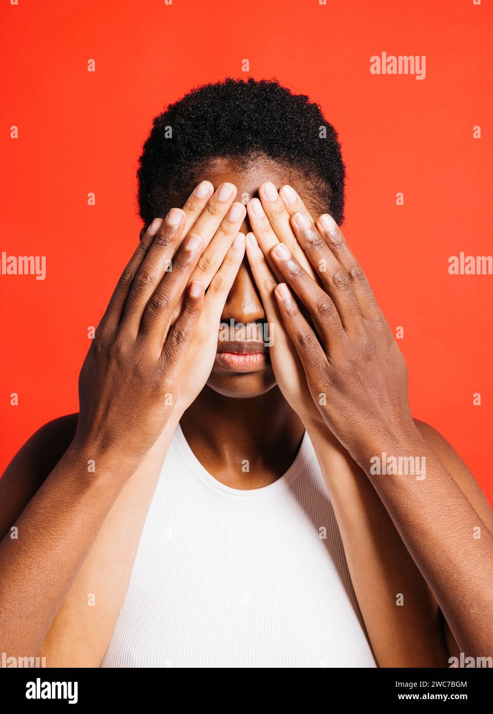 Portrait of young woman with her eyes covered by another woman's hands ...