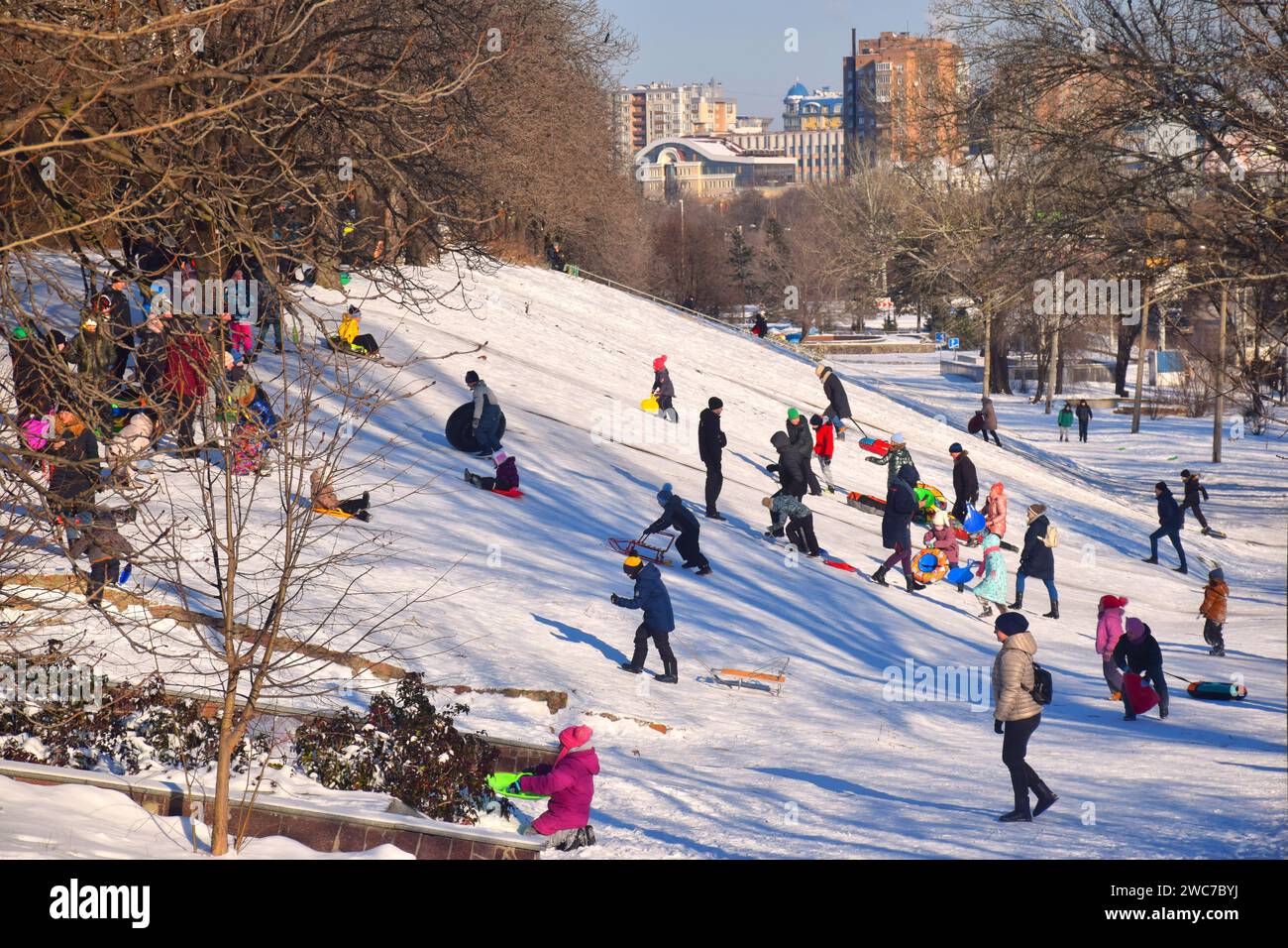 Happy family father, daughter and son are sledding in snow. Happy ...