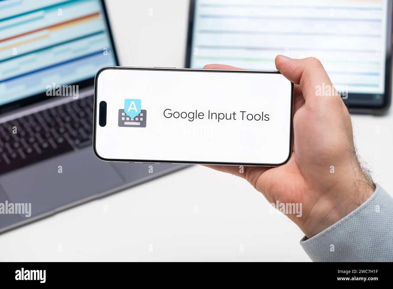 Google Input Tools logo of app on the screen of mobile phone held by ...
