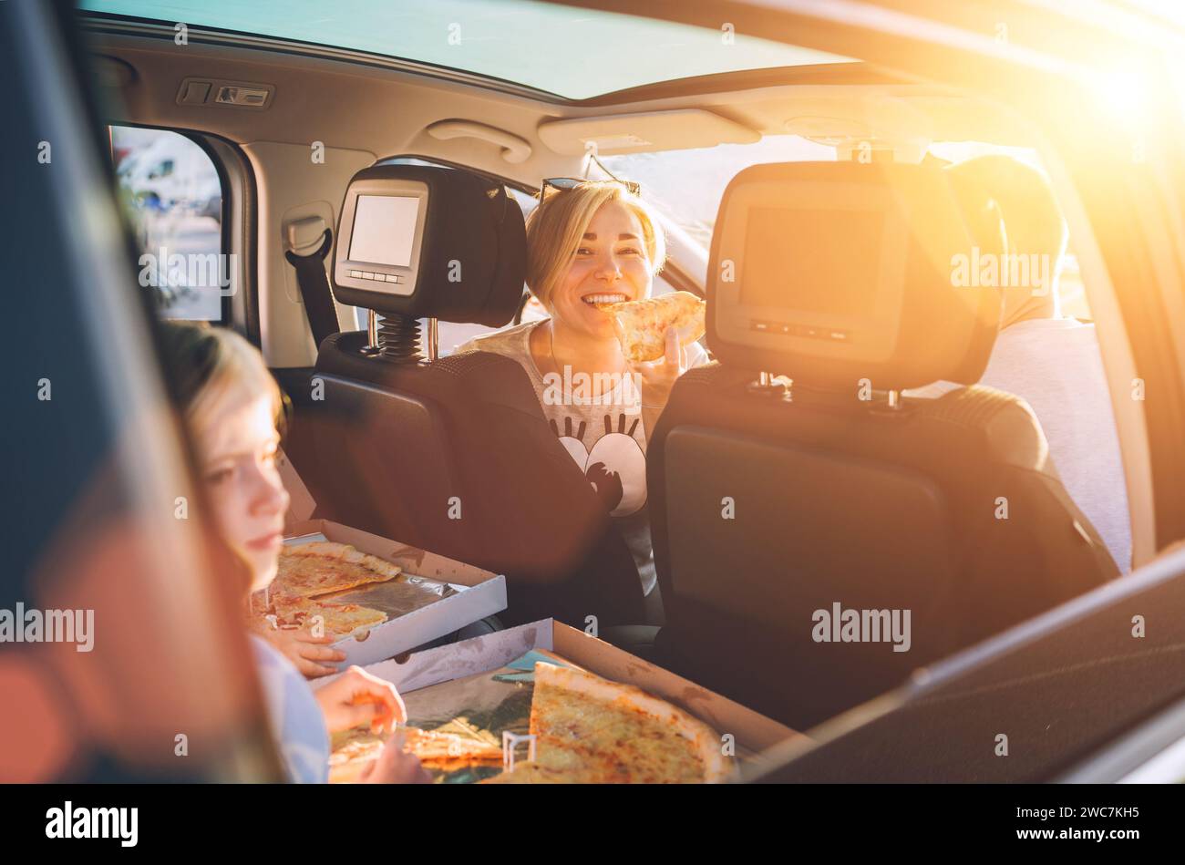 Portrait of young woman eating just cooked Italian pizza while she ...
