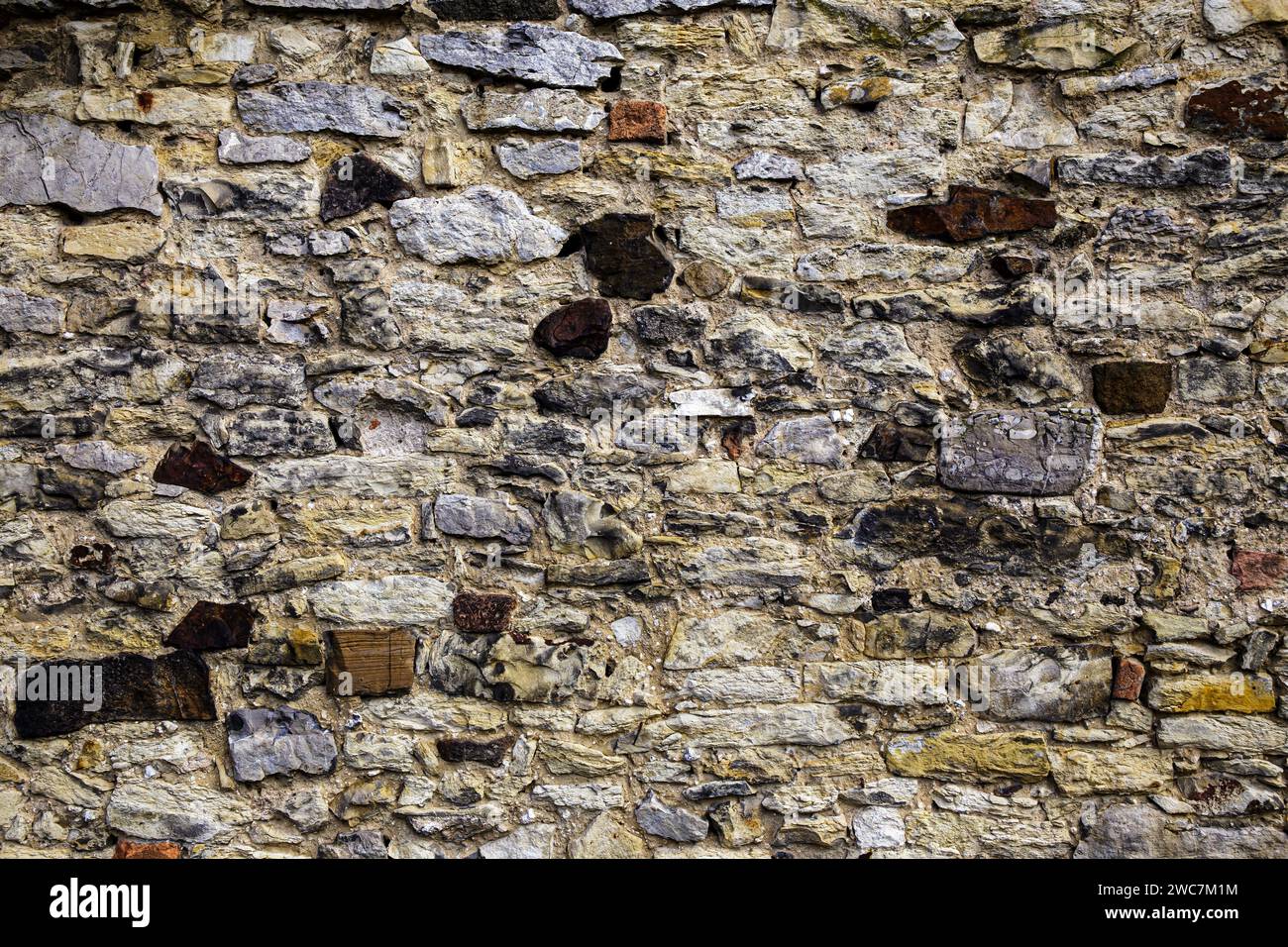Old shapeless stones create the texture of stone cladding background ...