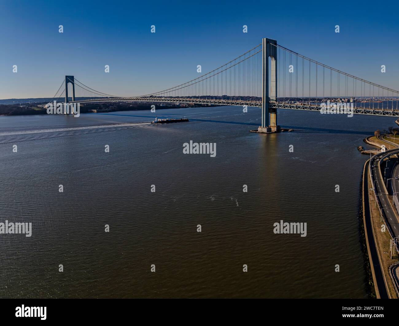 An uninhabited bridge stretches across a calm river, connecting both ...