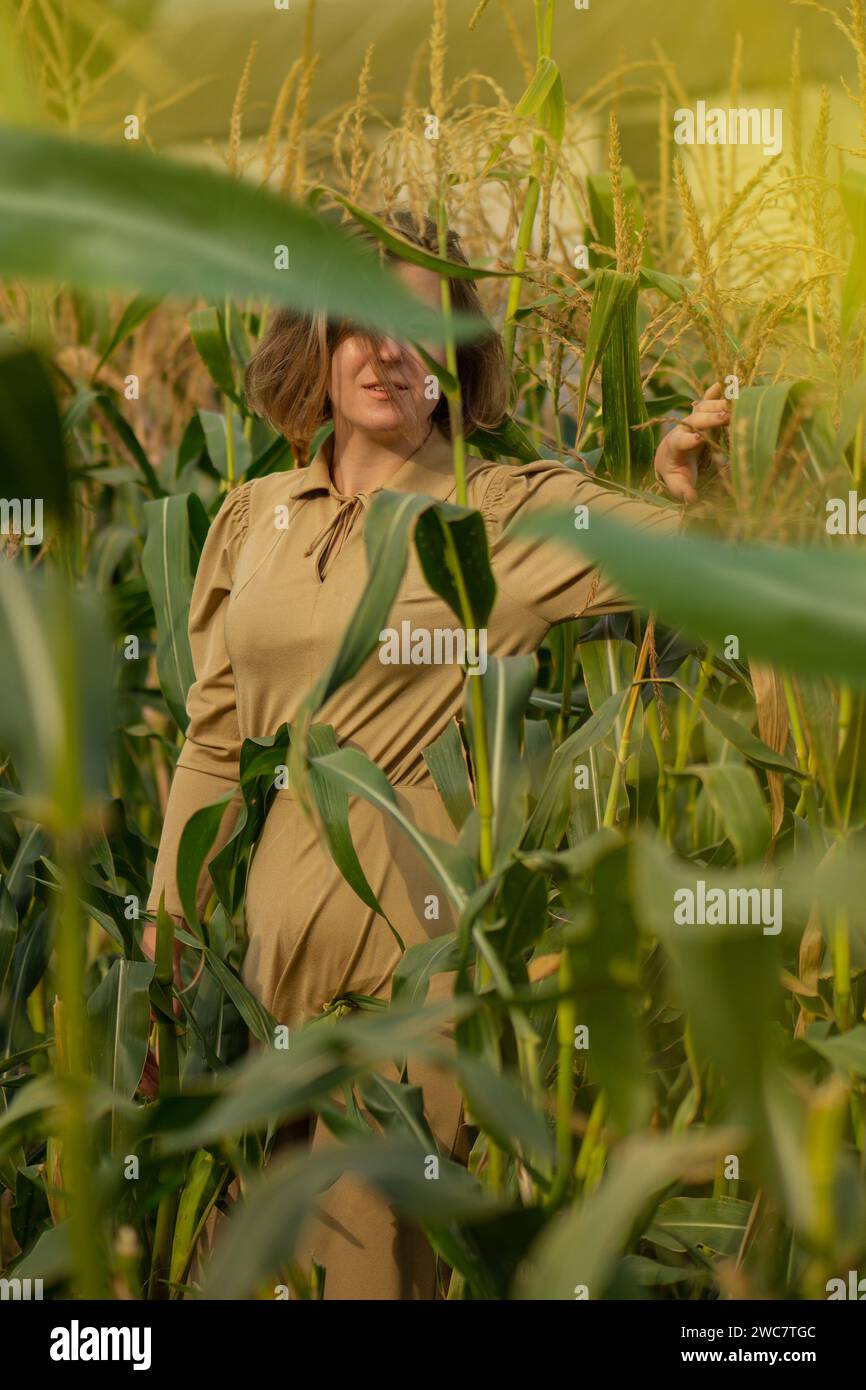 Happy pretty girl walks and posing in the thickets of a corn field ...