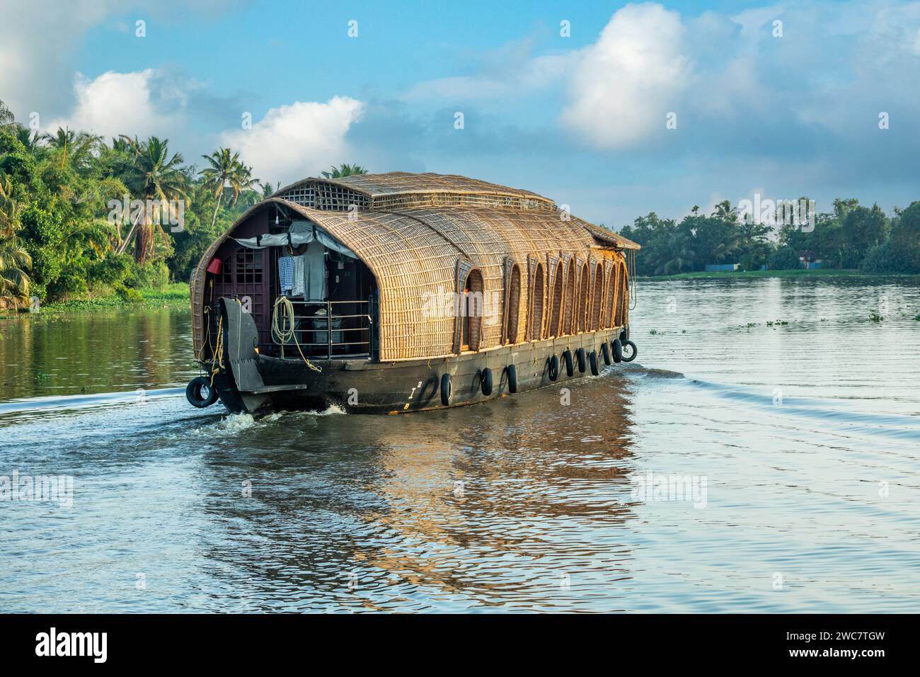 Indian traditional houseboats floating on Pamba river, with palms at ...