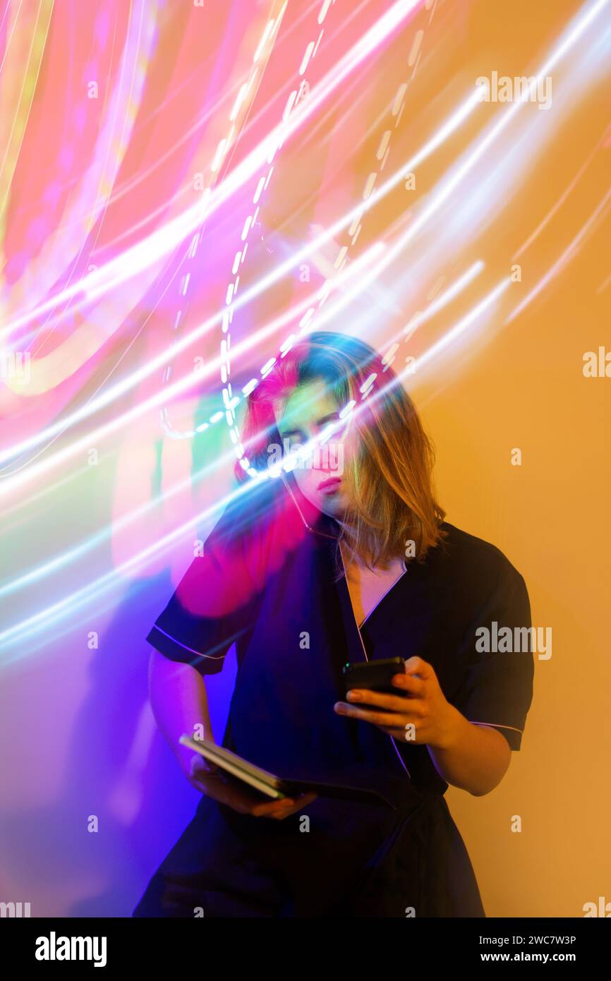 Female beauty salon worker masseuse using two phones at the same time ...