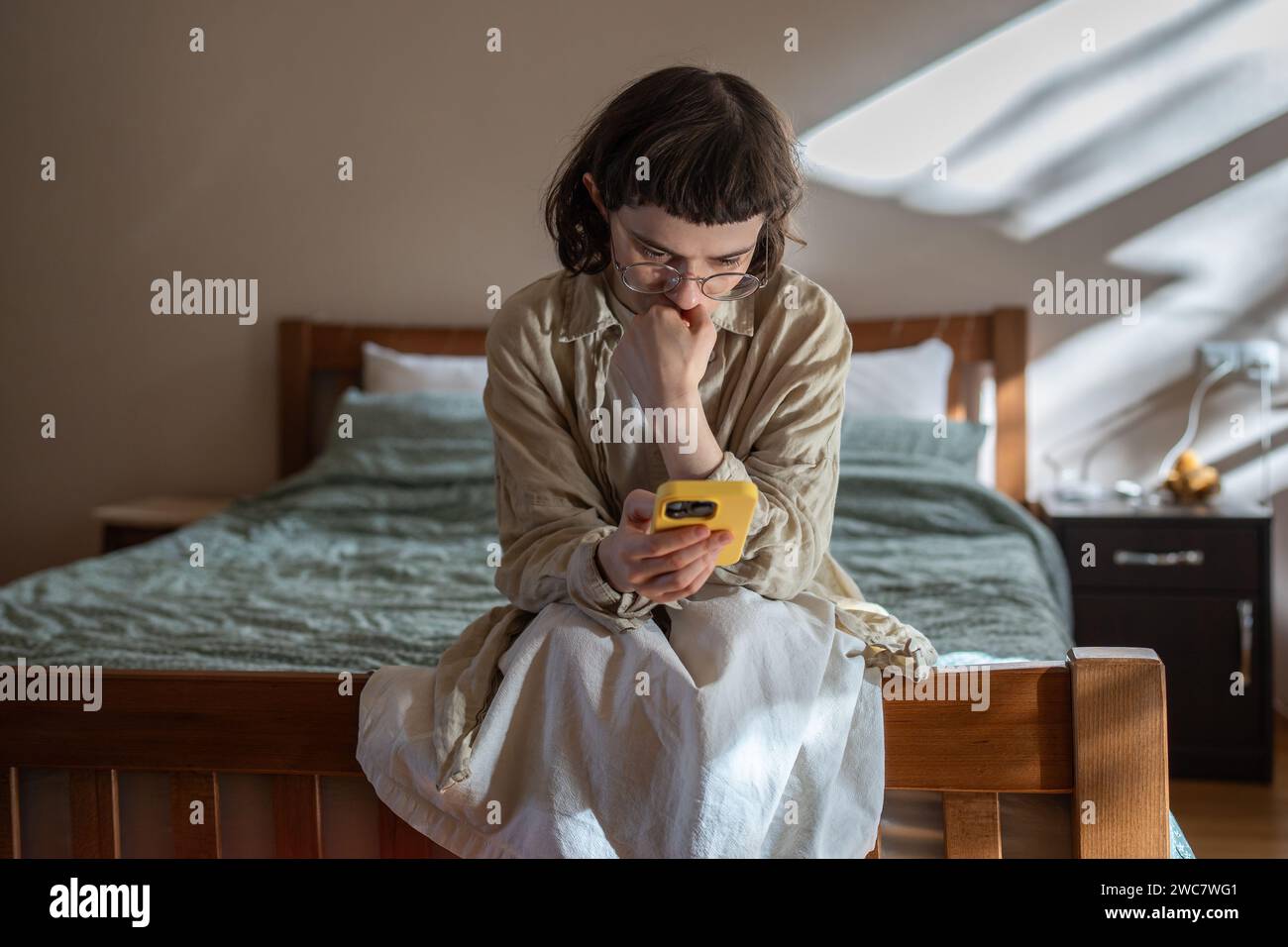 Nervous stressed teen girl in eyeglasses reading messages in smartphone ...