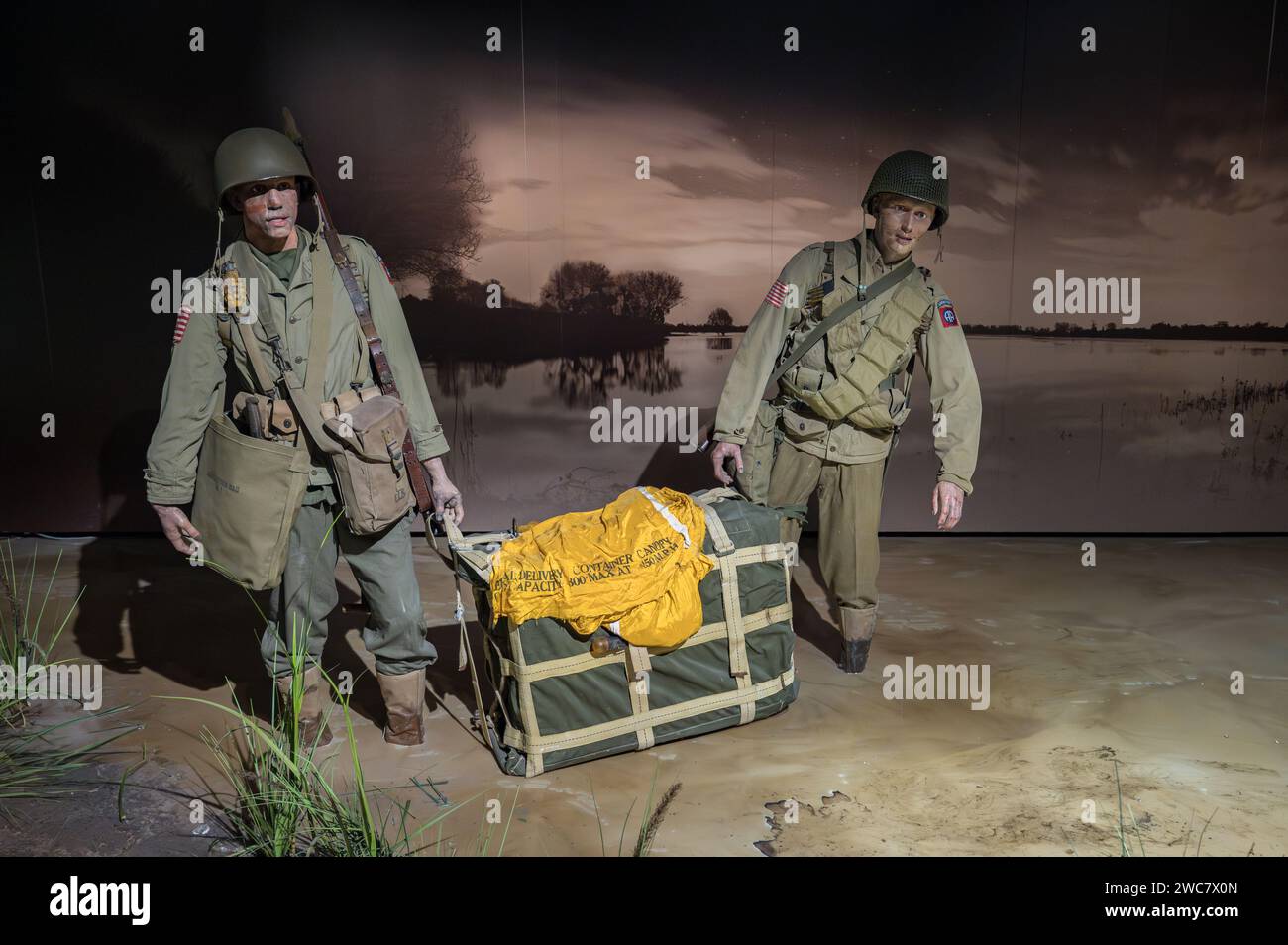 Couple of American airborne soldiers carrying a dropped supply box ...