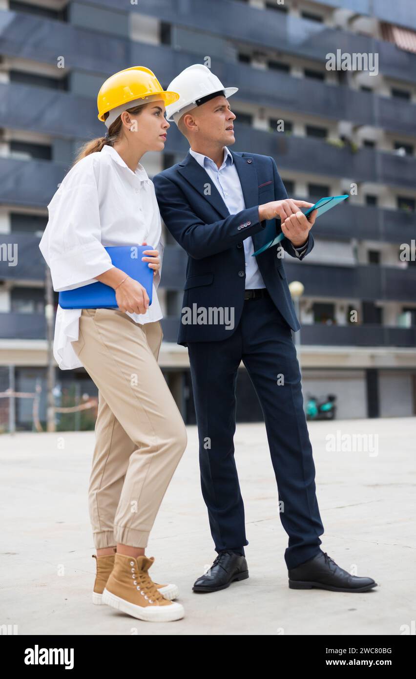 Civil engineers checking work process in construction site Stock Photo ...
