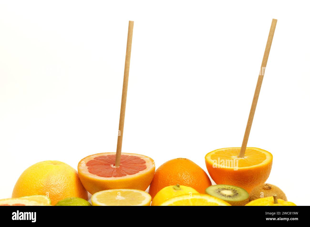 Fresh fruit cut in half with a drinking straw isolated on a white ...