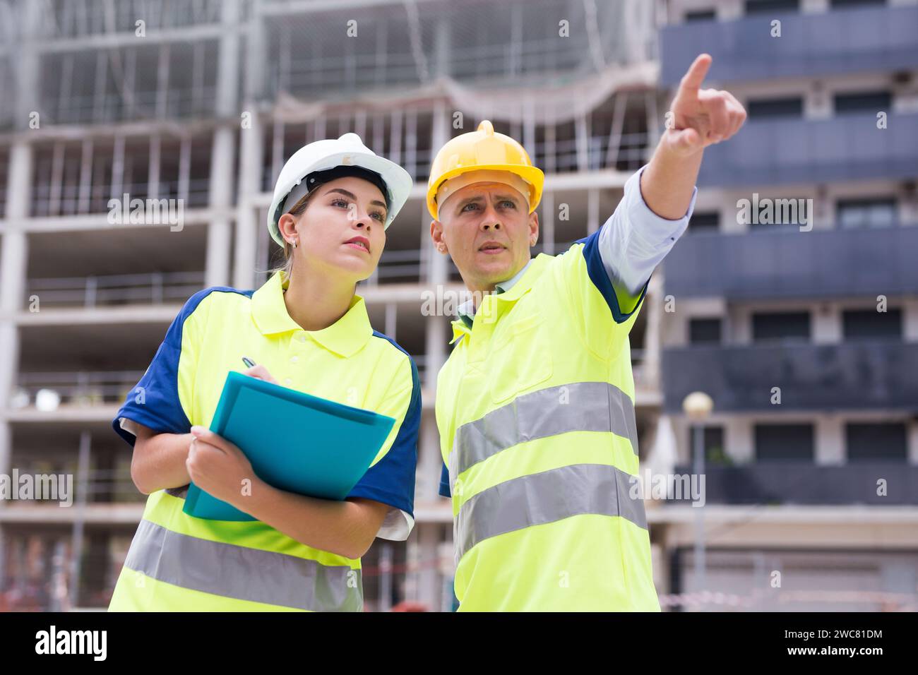 Civil engineers checking work process in construction site Stock Photo ...