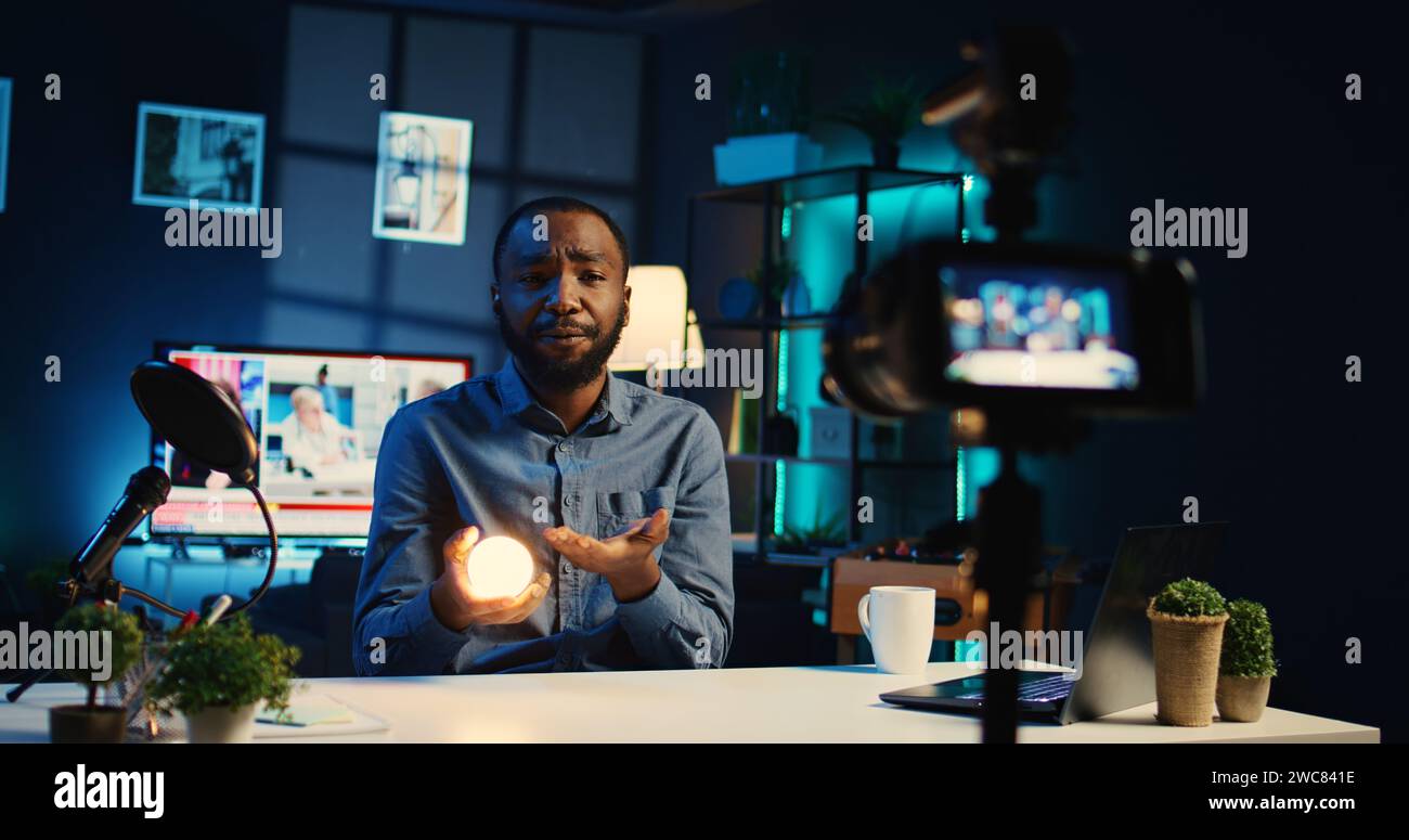 Influencer in dimly lit apartment studio uses camera to film smart ...