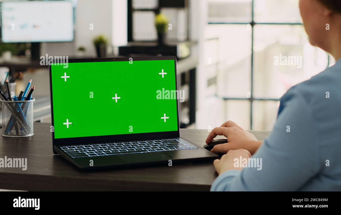 Company specialist using laptop with greenscreen template, working with ...