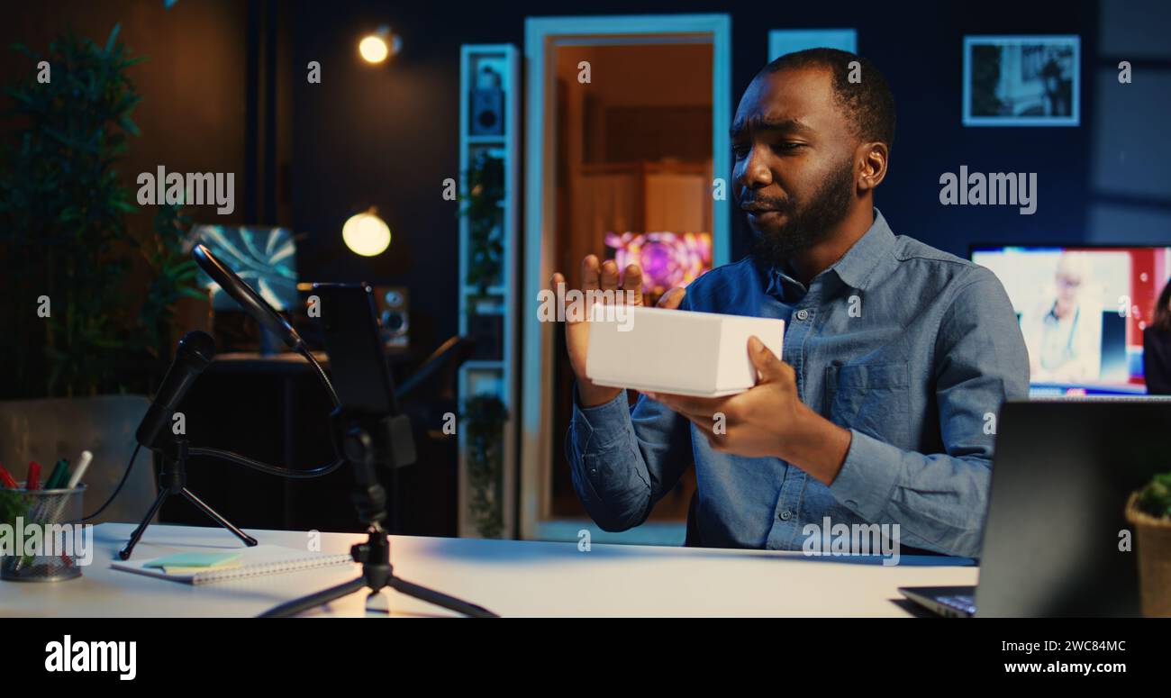 Tech content creator filming packaged product unboxing, unpacking it ...