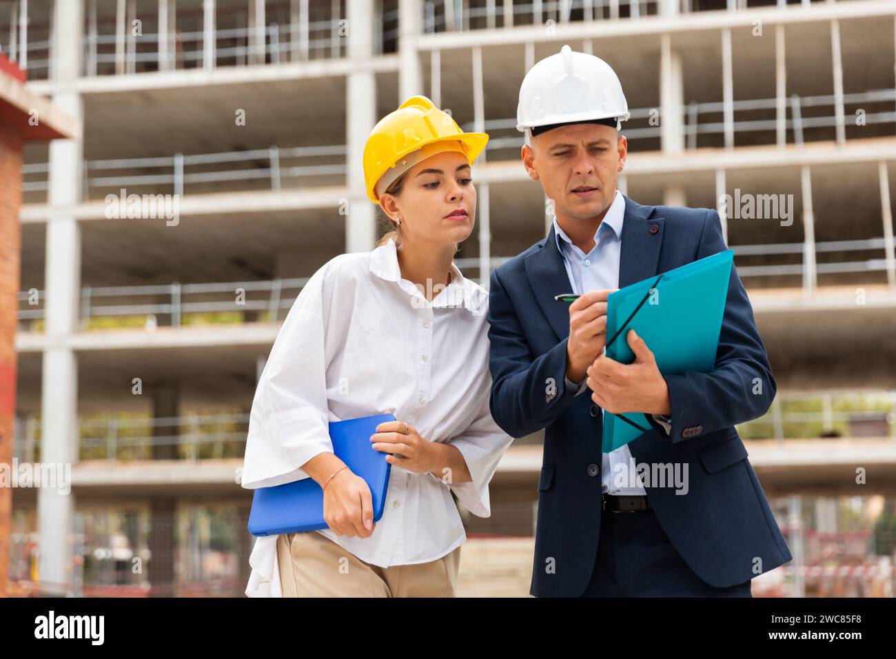 Civil engineers checking work process in construction site Stock Photo ...