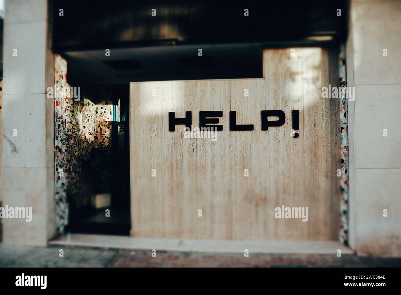 The text HELP written with big black letters on a concrete wall ...