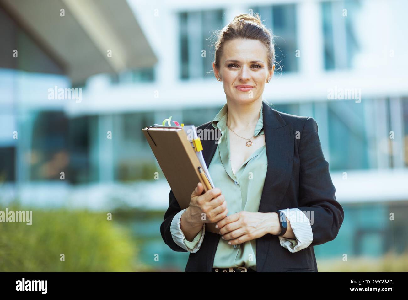 Portrait of modern 40 years old woman employee near office building in ...