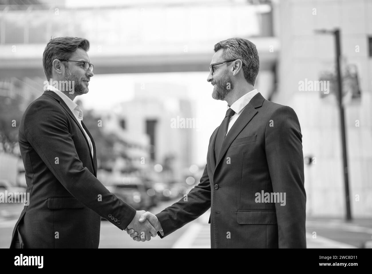 two cheerful business partners dealing with handshake. two business ...