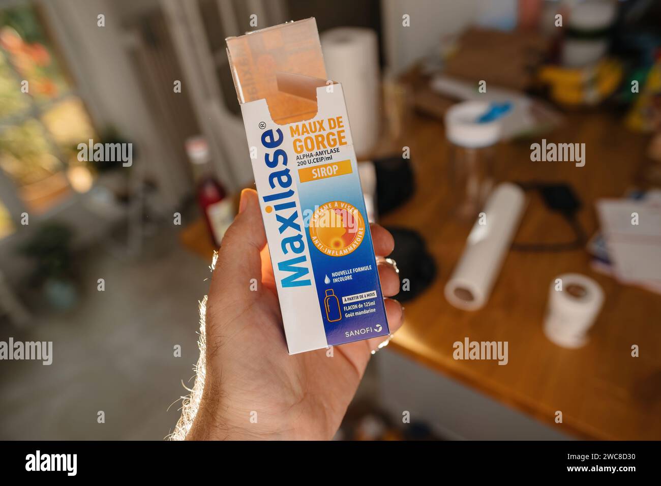 Frankfurt, Germany - Jun 12, 2023: A hand holds a box of Maxilase sore ...