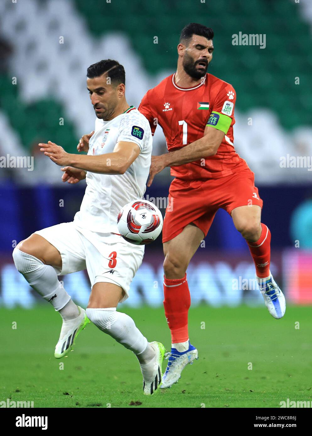 Iranian Ehsan Hajsafi (L) and Palestinian MUS'AB AL BATTAT struggle to hold a ball in the first ...