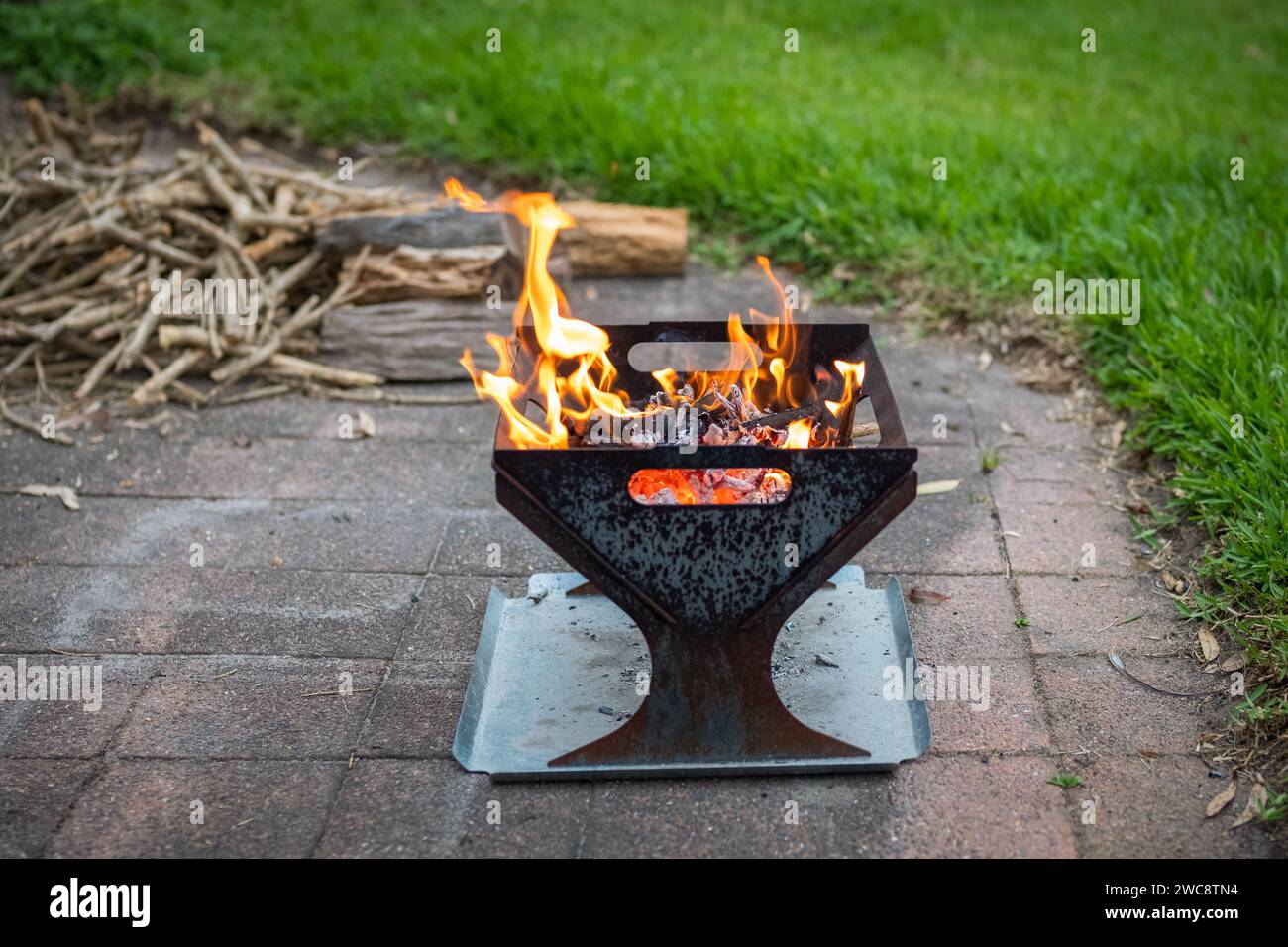 Campfire, fire pit filled with burnt wood and flames. Chopped fire wood ...