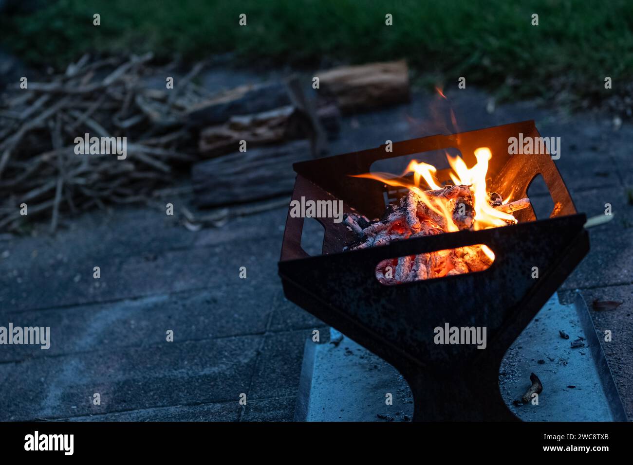 Campfire, fire pit filled with burnt wood and flames. Chopped fire wood ...