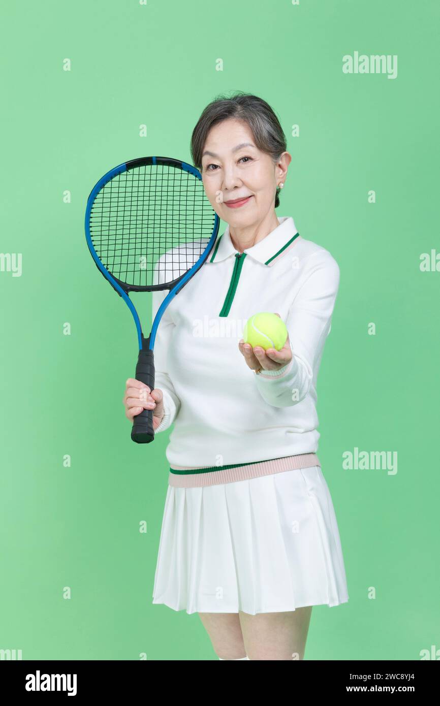 A senior woman holding a tennis racket and a tennis ball Stock Photo ...