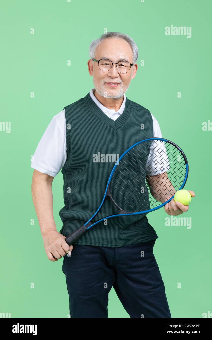 A senior male holding a tennis racket and a tennis ball Stock Photo - Alamy