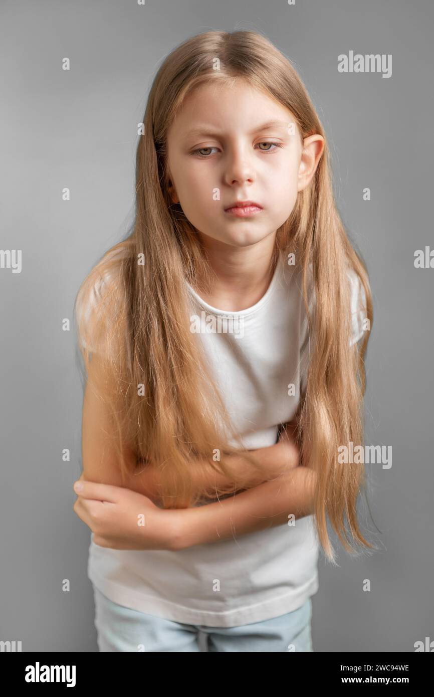 Little girl holding her stomach. Abdominal pain Stock Photo - Alamy