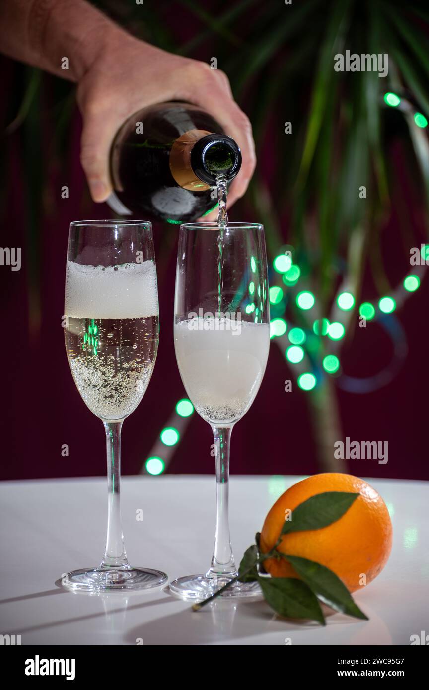 Pouring of brut champagne, cava or prosecco dry wine in glasses with ...