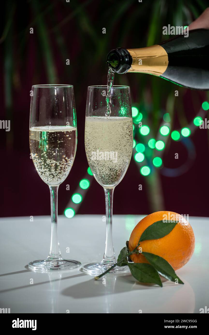 Pouring of brut champagne, cava or prosecco dry wine in glasses with ...