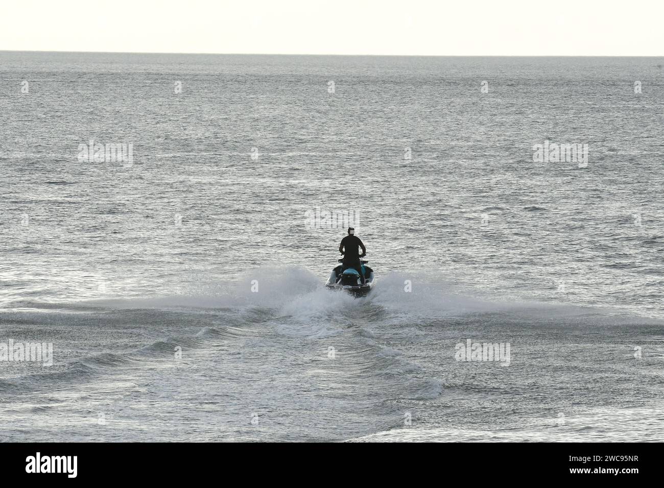 A male adventurer joyfully rides a jet ski, creating an impressive ...