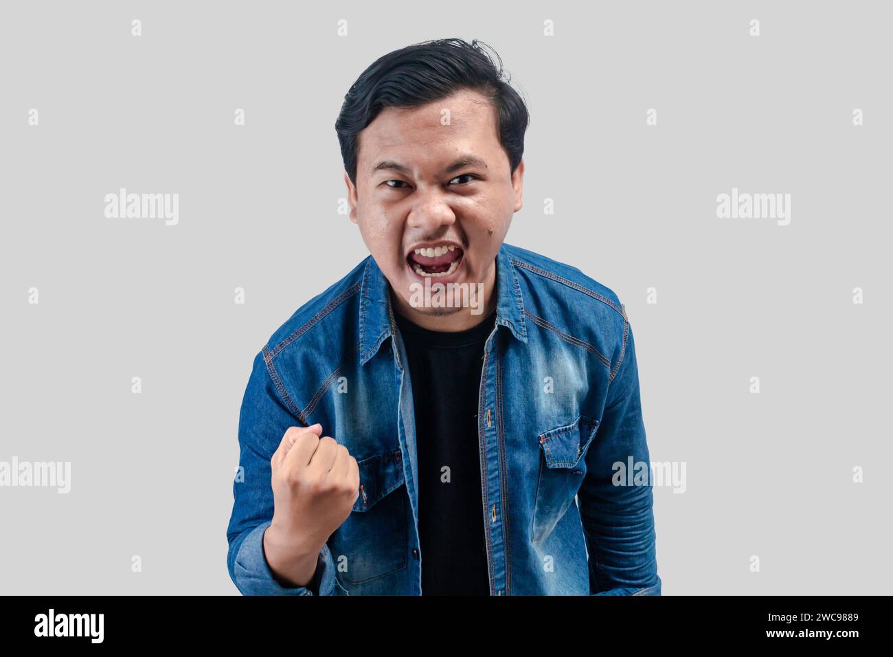 Young Asian Man raised his fist with a happy smile on his face as a ...