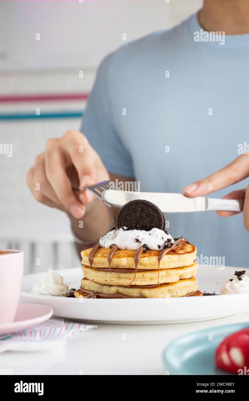 Chocolate cookie pancake in a cafe restaurant, make eating with knife ...