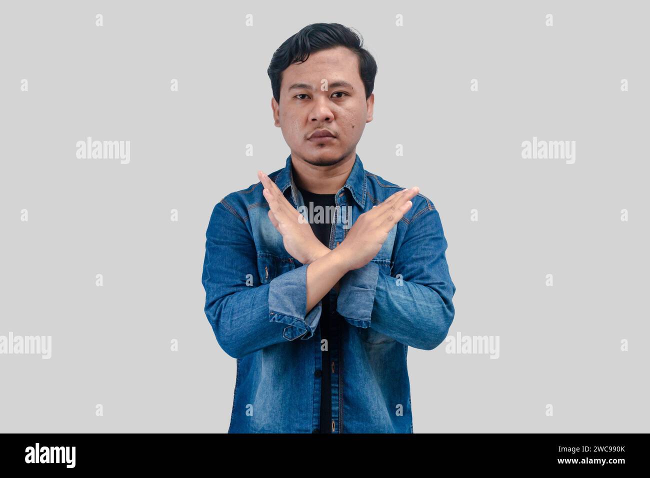 Young Asian Man unhappy or confident standing wear holding two cross ...