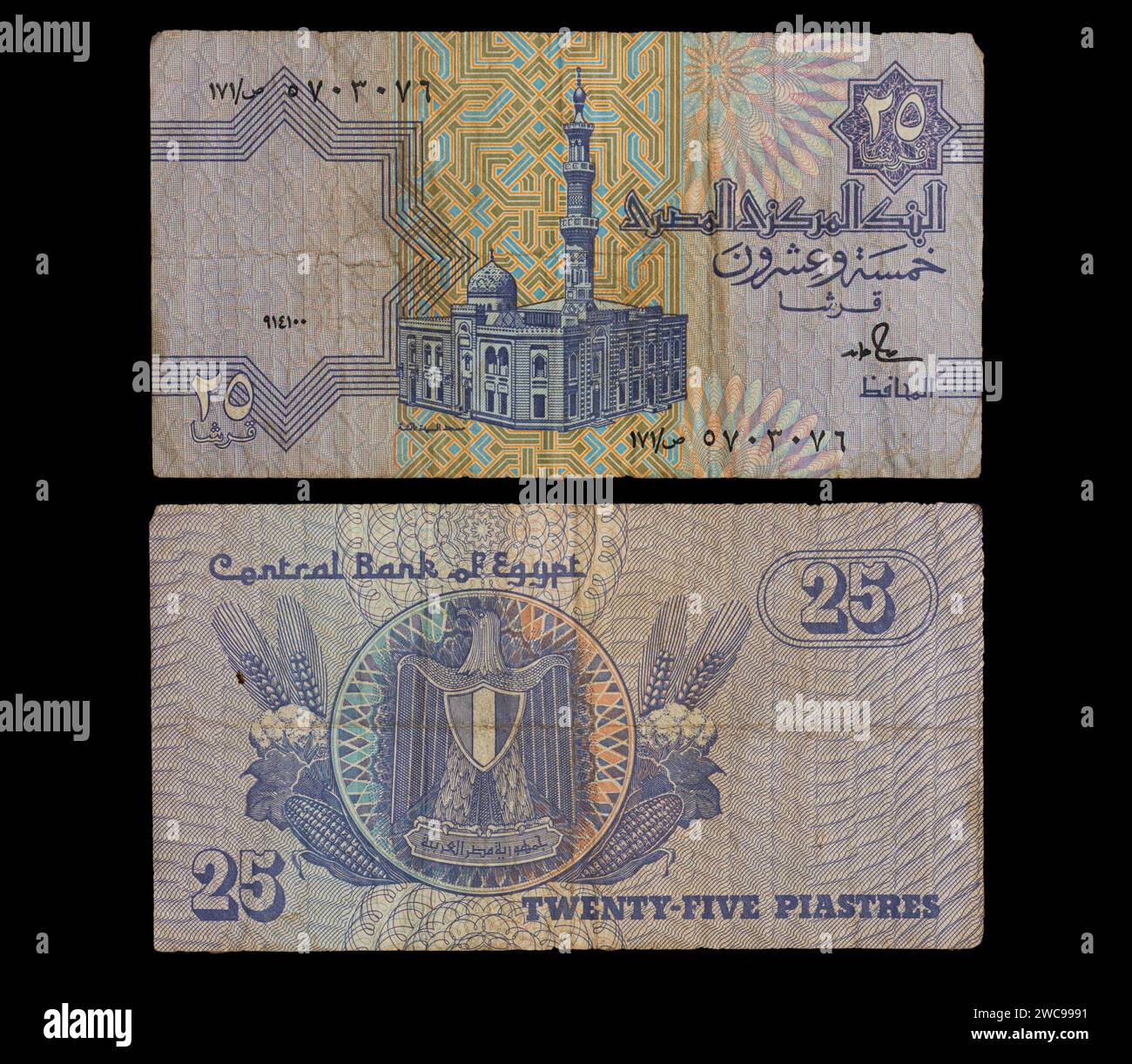 The two Egyptian banknotes placed side by side on a sleek black surface ...