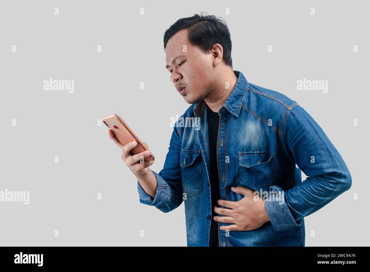 Young asian man having stomach ache or indigestion and pressing his ...