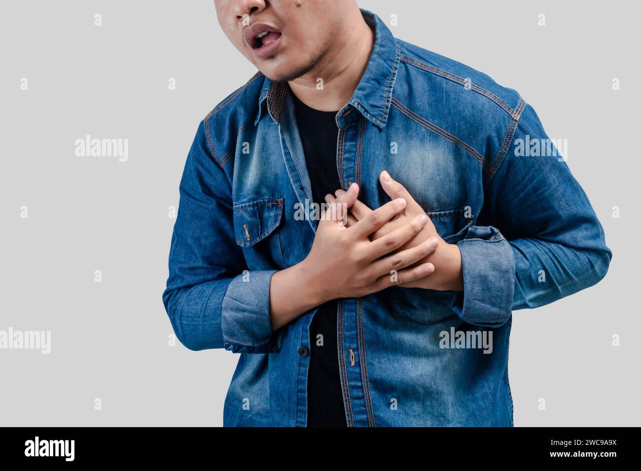 Young Asian man having chest pain or heart trouble and pressing his ...