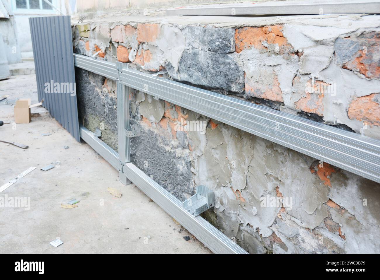 House foundation wall repair, renovation with installing metal sheets ...