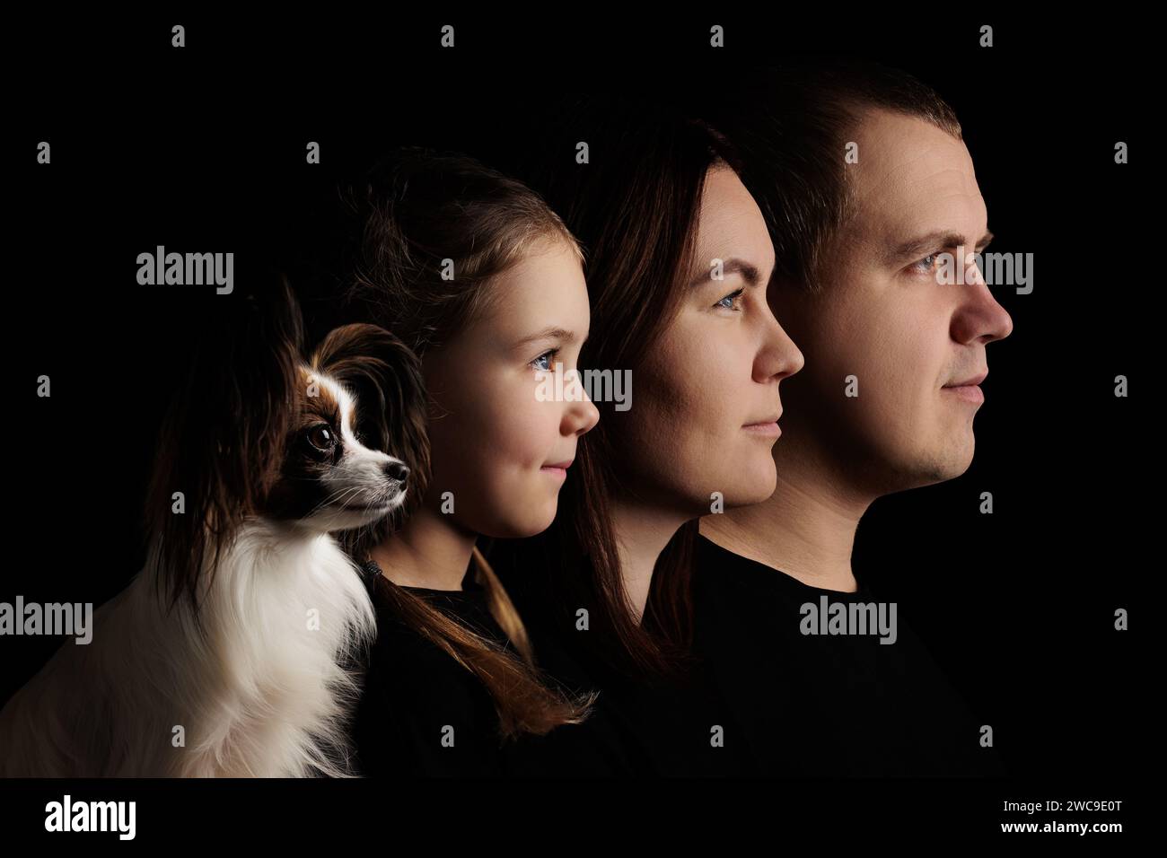 Side view portrait of young family on dark background Stock Photo - Alamy