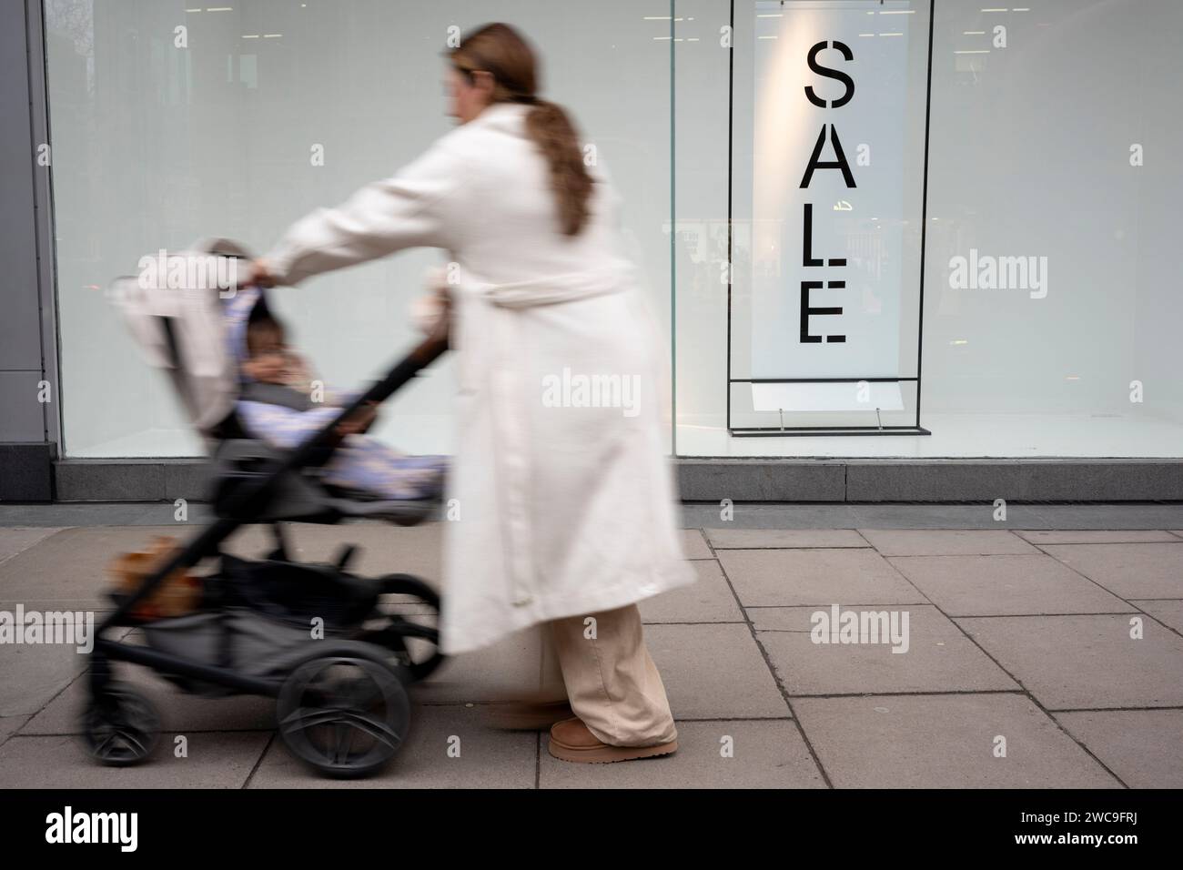 A shopper and her child pass-by a generic shop business whose January ...
