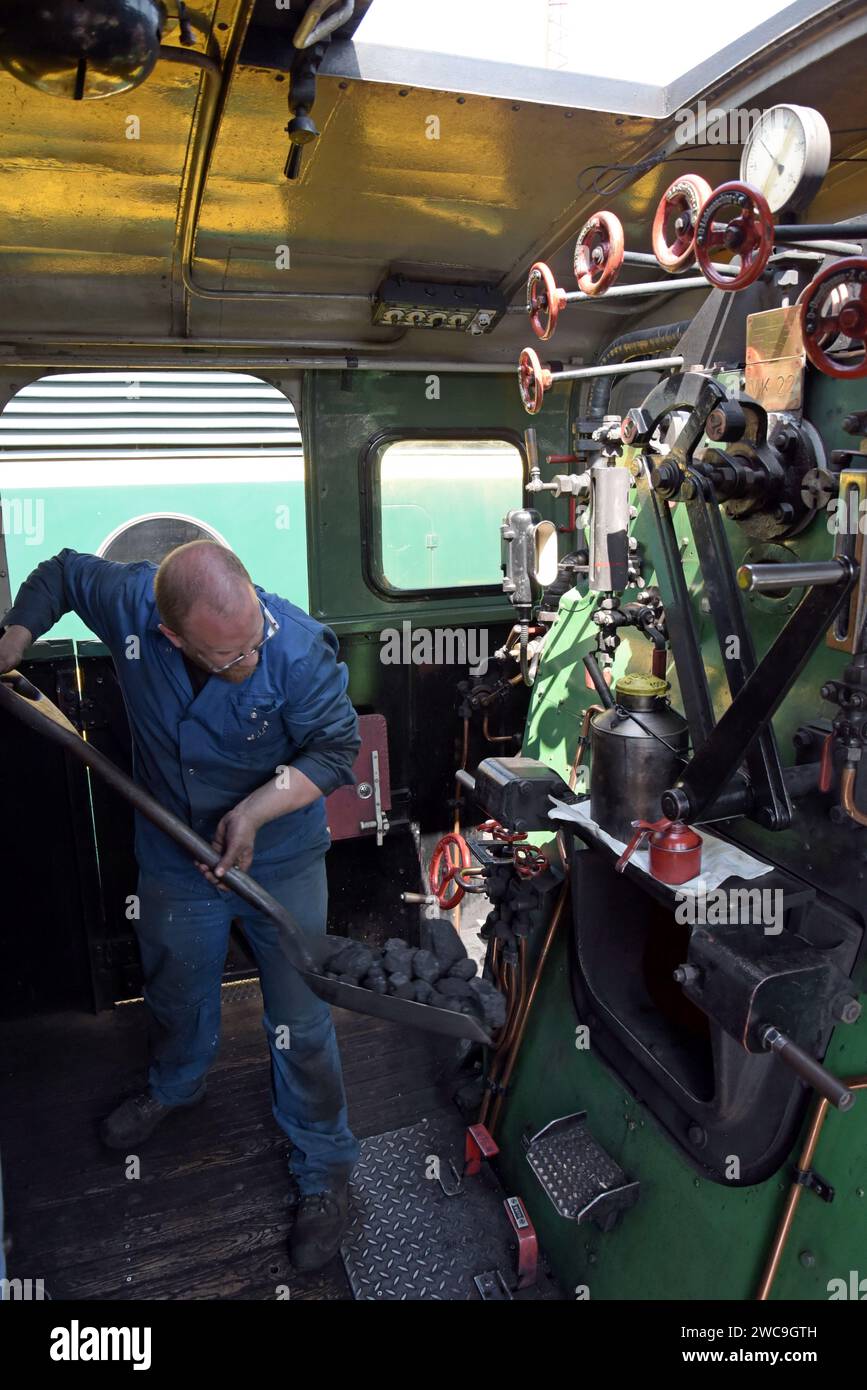 Steam loco fireman shovelling coal on a Krupp steam loco at the ...