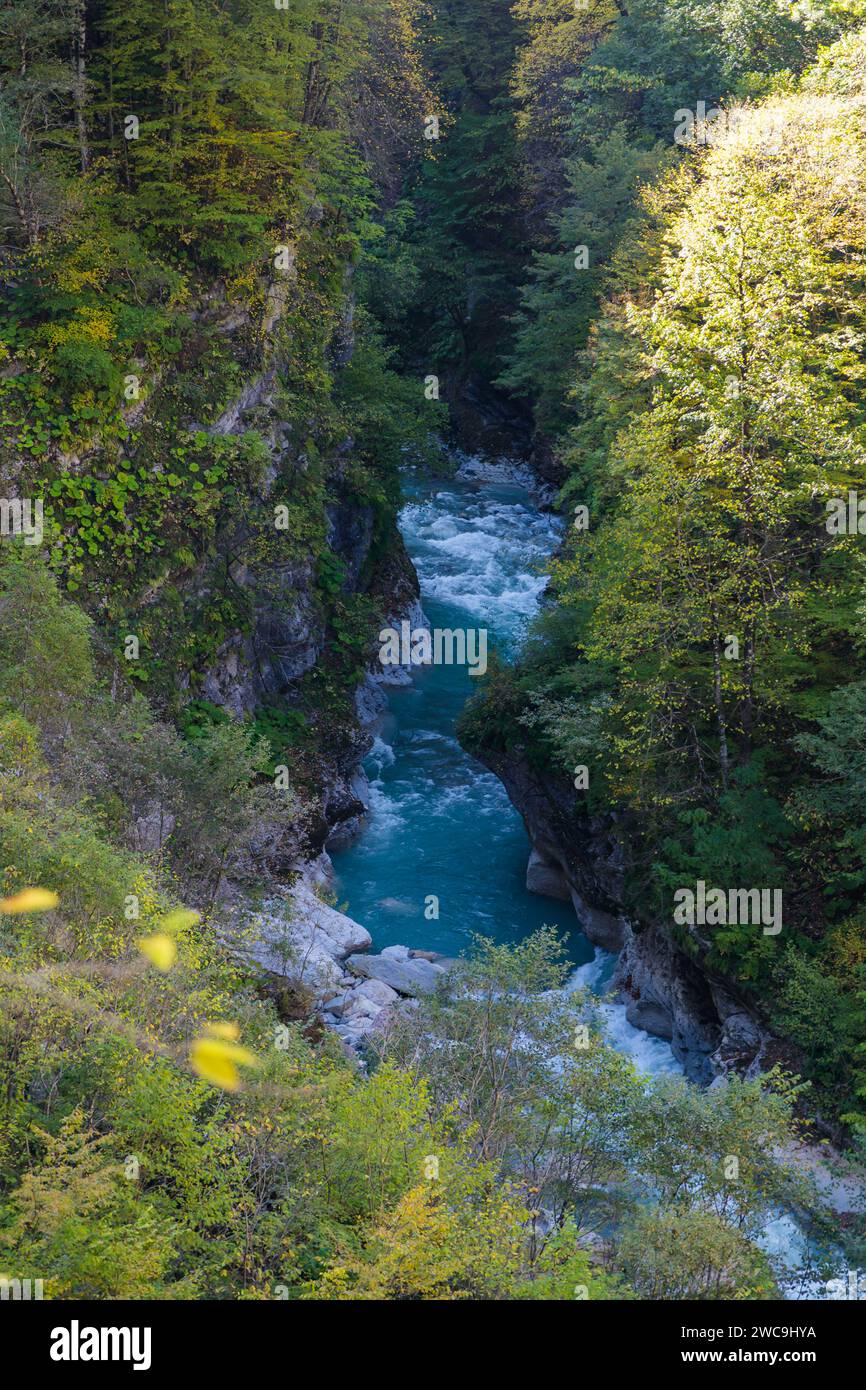 A mountain gorge with a fast flowing river, surrounded by high cliffs ...