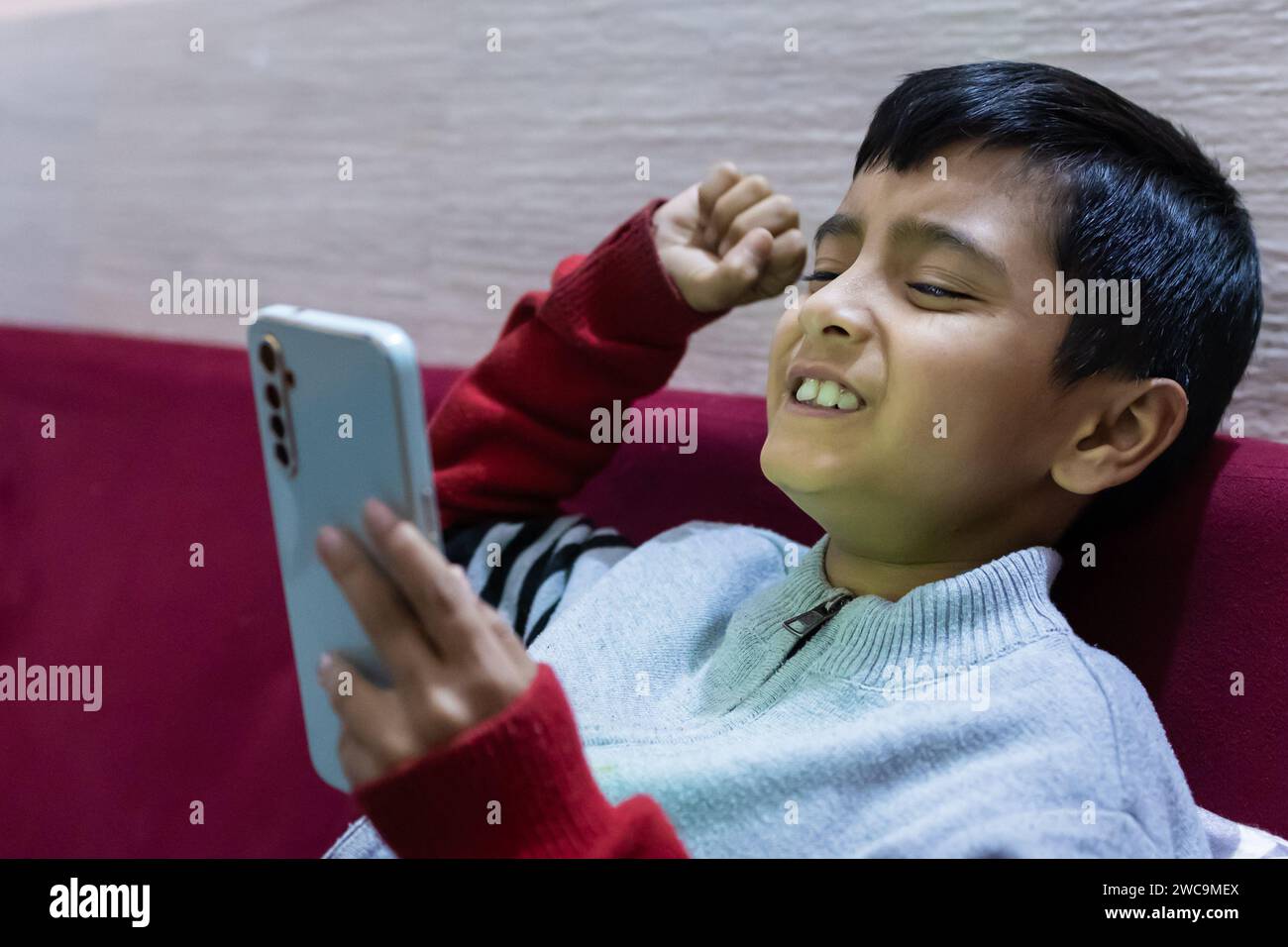 young kid facial expression while watching mobile and playing online ...